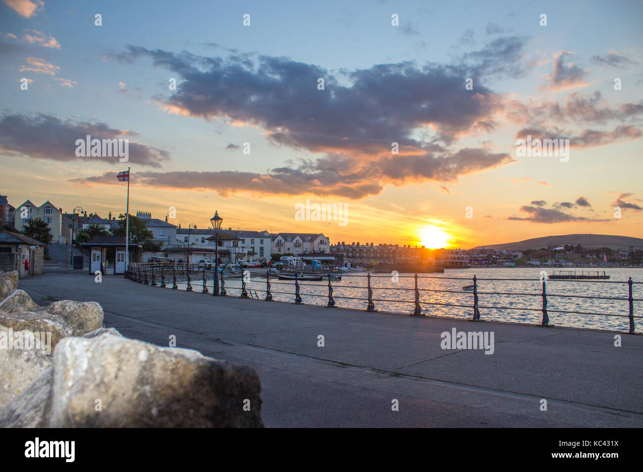 Entrance to the promenade and pier, with setting sun over beach and ...