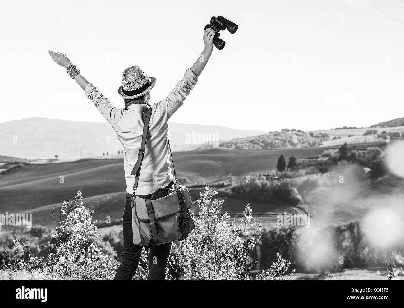 Discovering magical views of Tuscany. Seen from behind woman hiker with ...