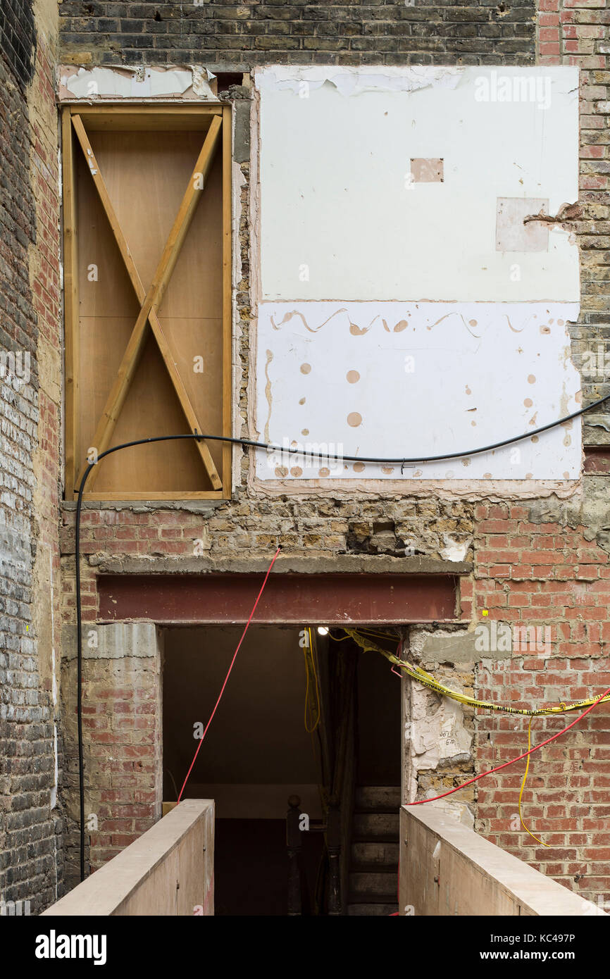 View across temporary bridge looking at boarded up doorways. Kettner's ...