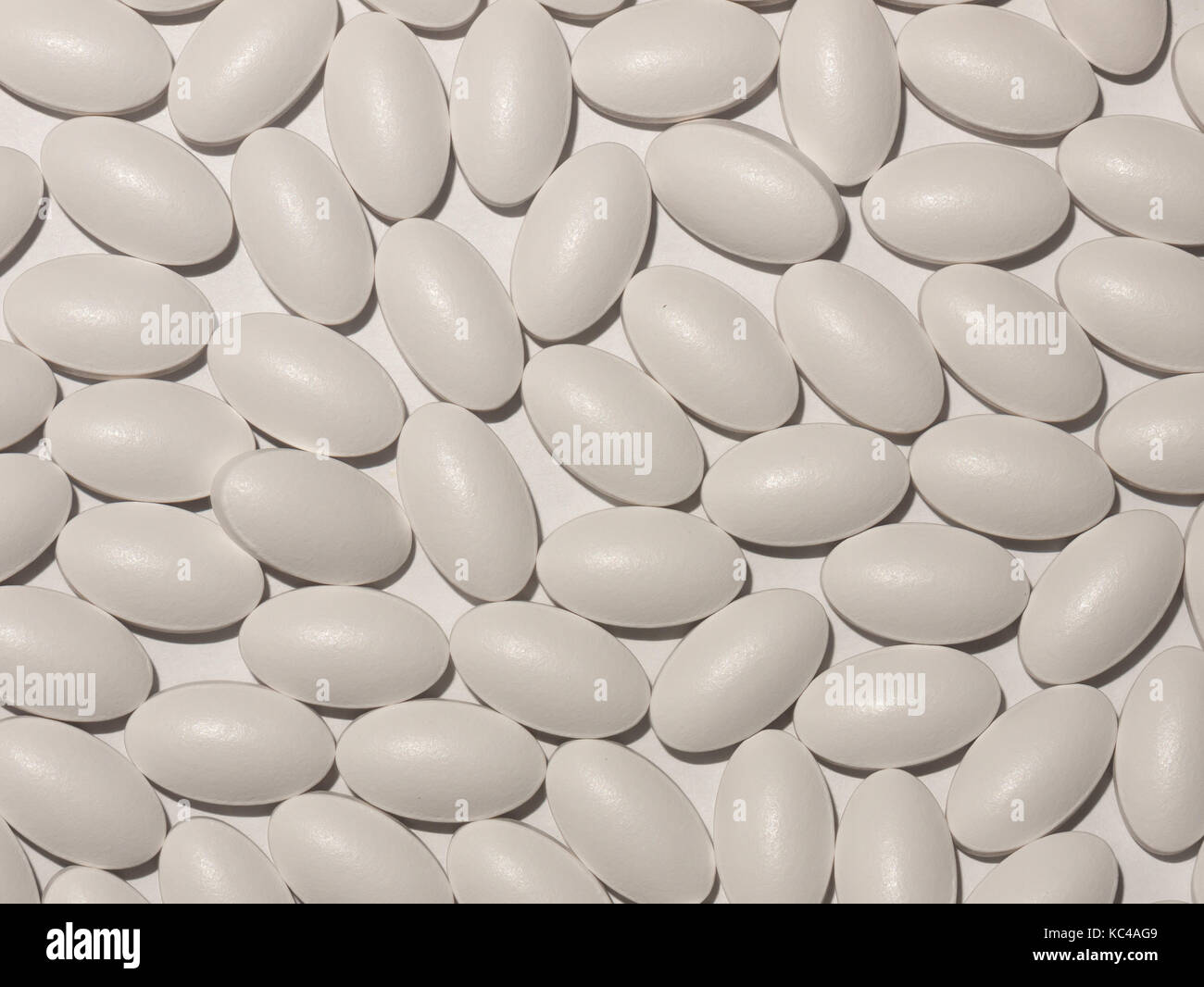 many white generic tablet pills on a white background; Essex; England ...