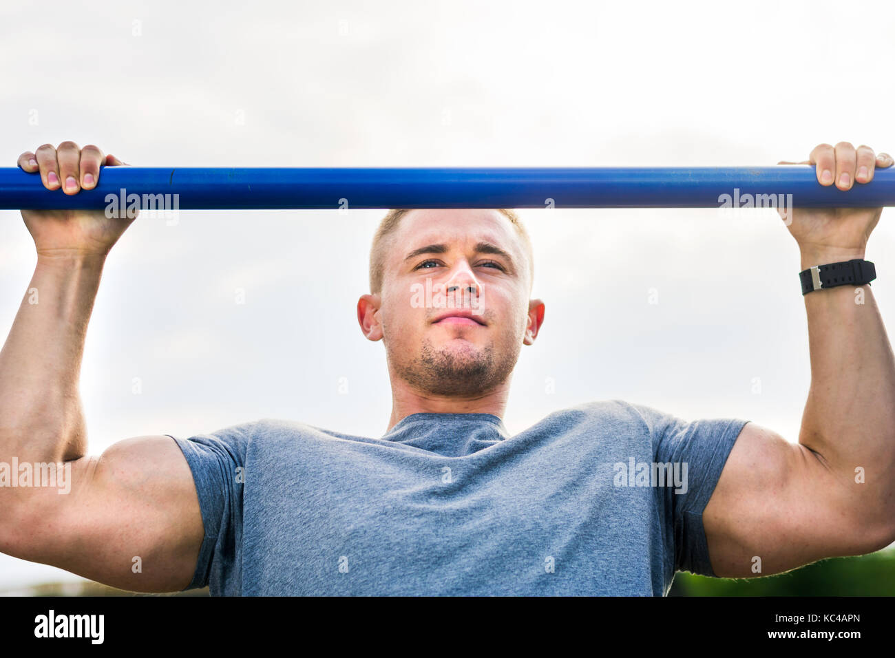 Masculine man doing pull ups on street workout outdoors Stock Photo - Alamy