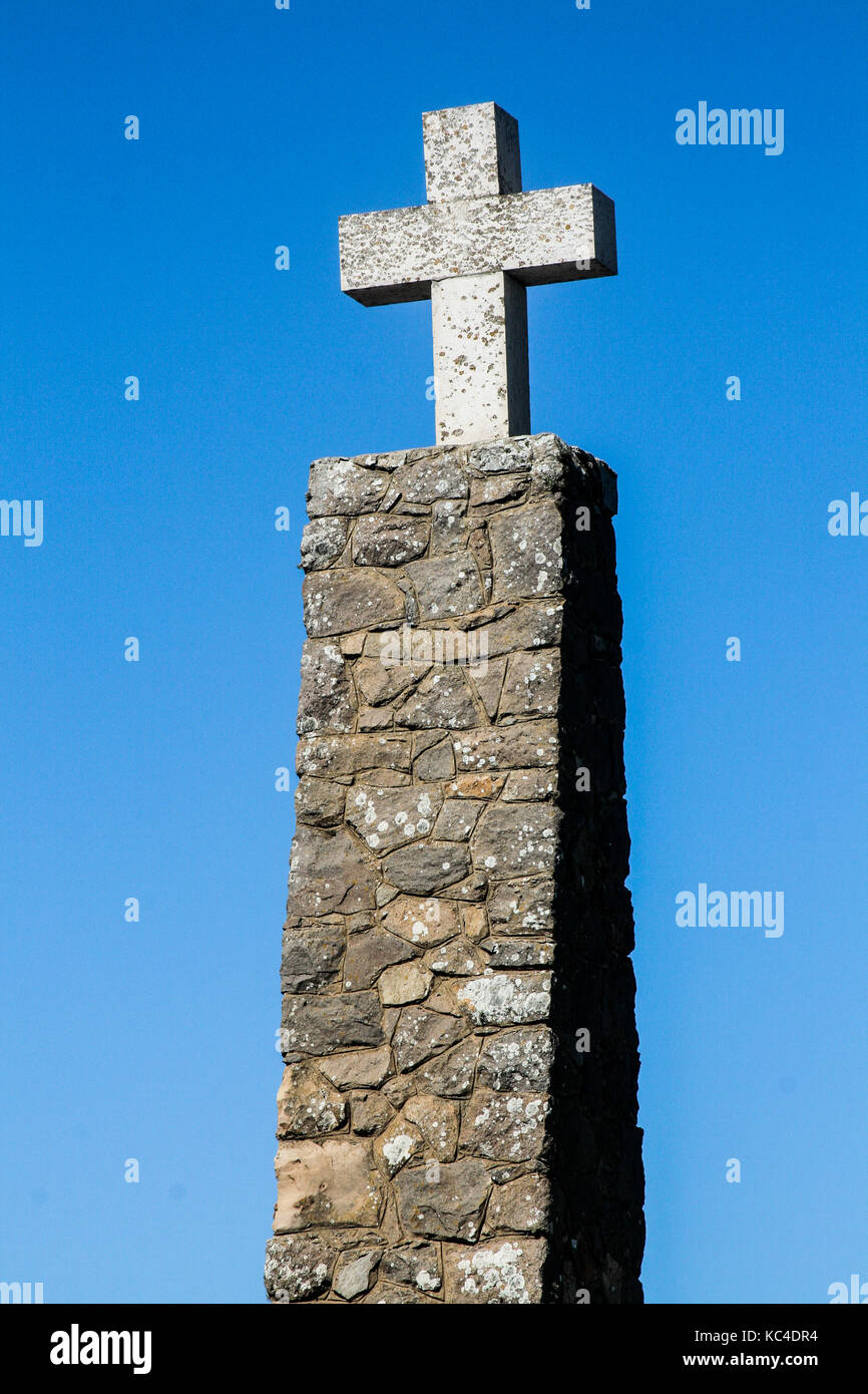 Cross, Christian symbol, on a stone pillar against blue sky, Portugal ...