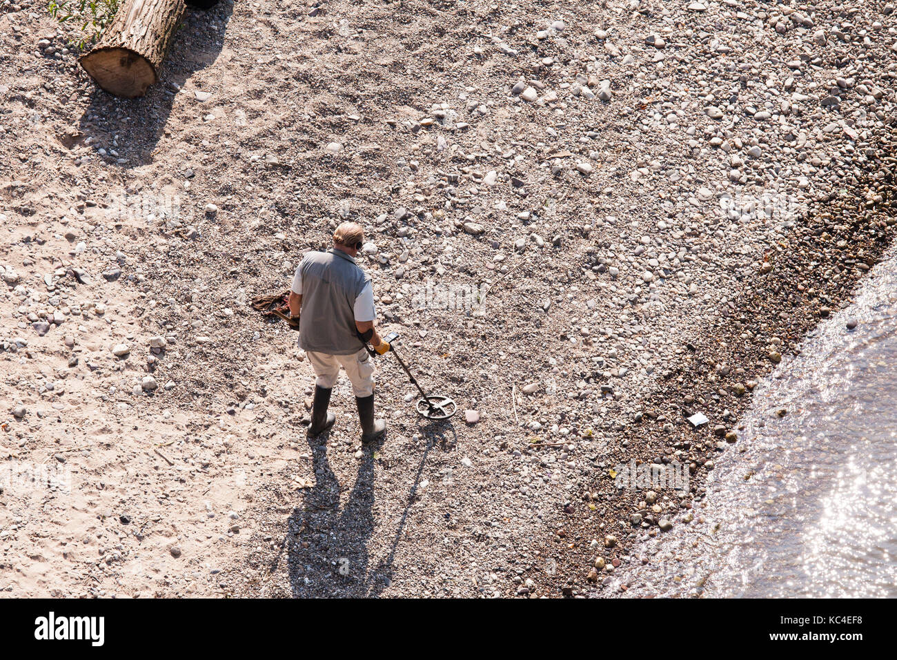 Germany, Cologne, man with metal detector at the banks of the river ...