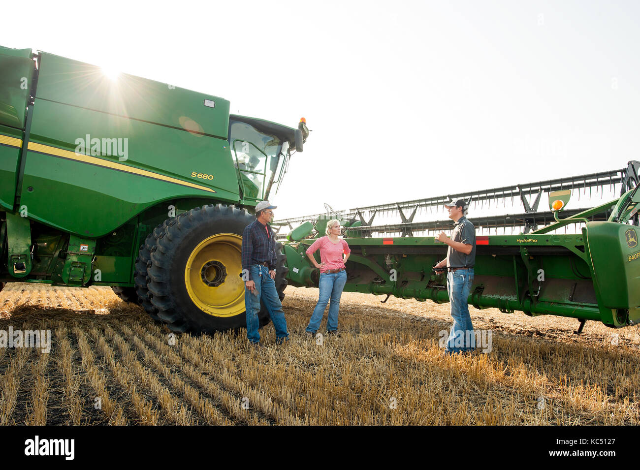 A YOUNG FEMALE FARMER TALKS WITH HIRED HANDS, AS WELL AS A GPS ...