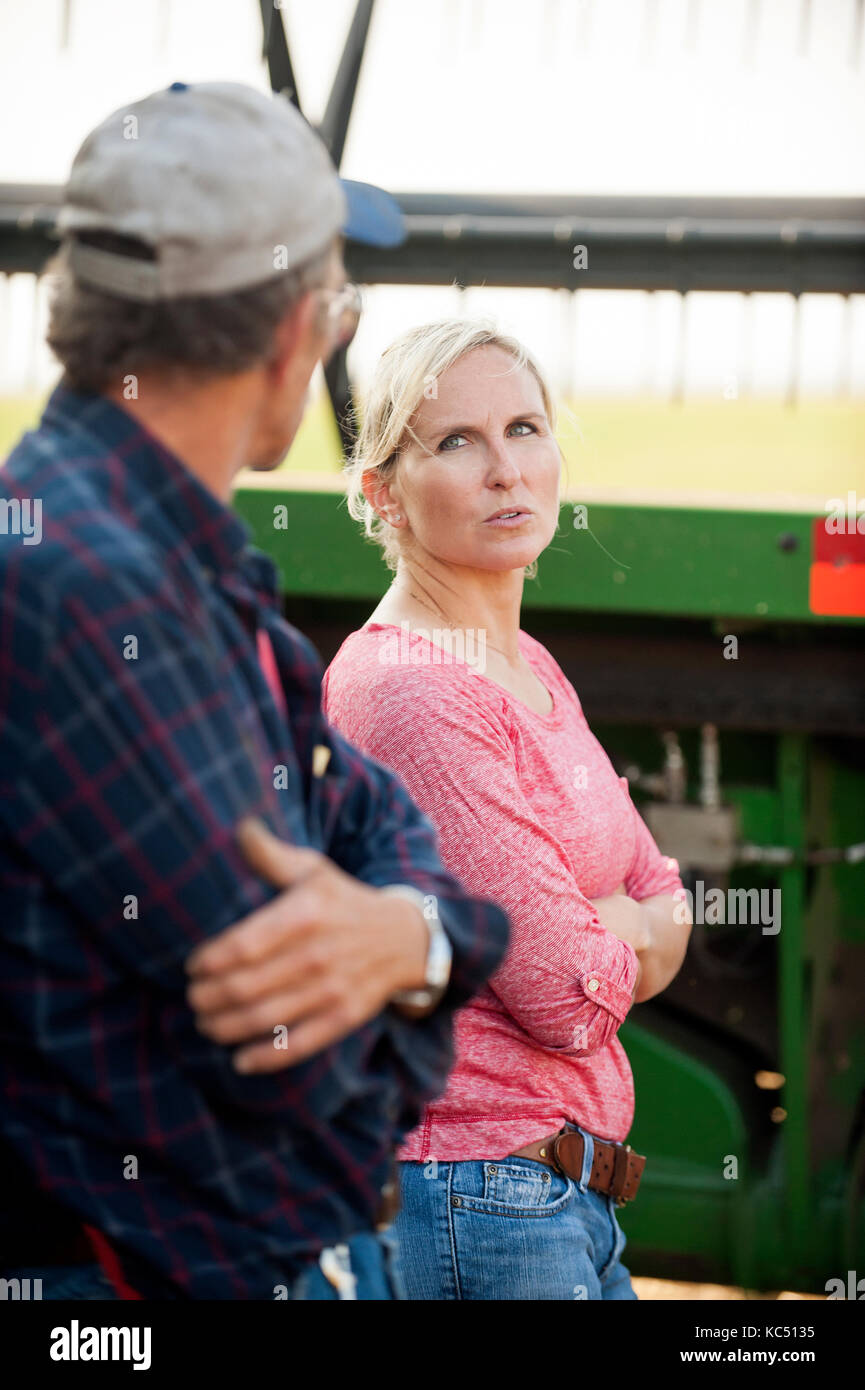 A YOUNG FEMALE FARMER TALKS WITH A HIRED HAND PRIOR TO HEADING OUT TO ...