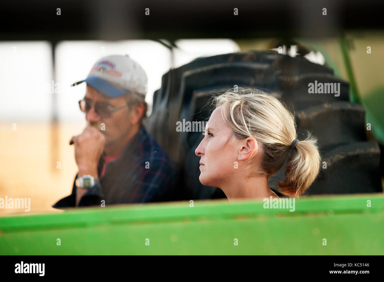 A YOUNG FEMALE FARMER TALKS WITH A HIRED HAND PRIOR TO HEADING OUT TO ...