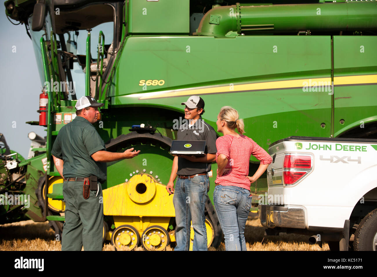 A YOUNG FEMALE FARMER TALKS WITH HIRED HANDS, AS WELL AS A GPS ...