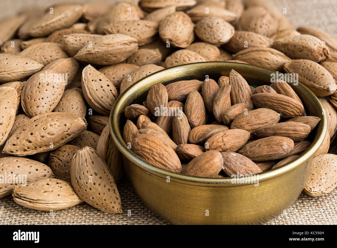 Almonds peeled in a bowl or in their nutshell Stock Photo - Alamy