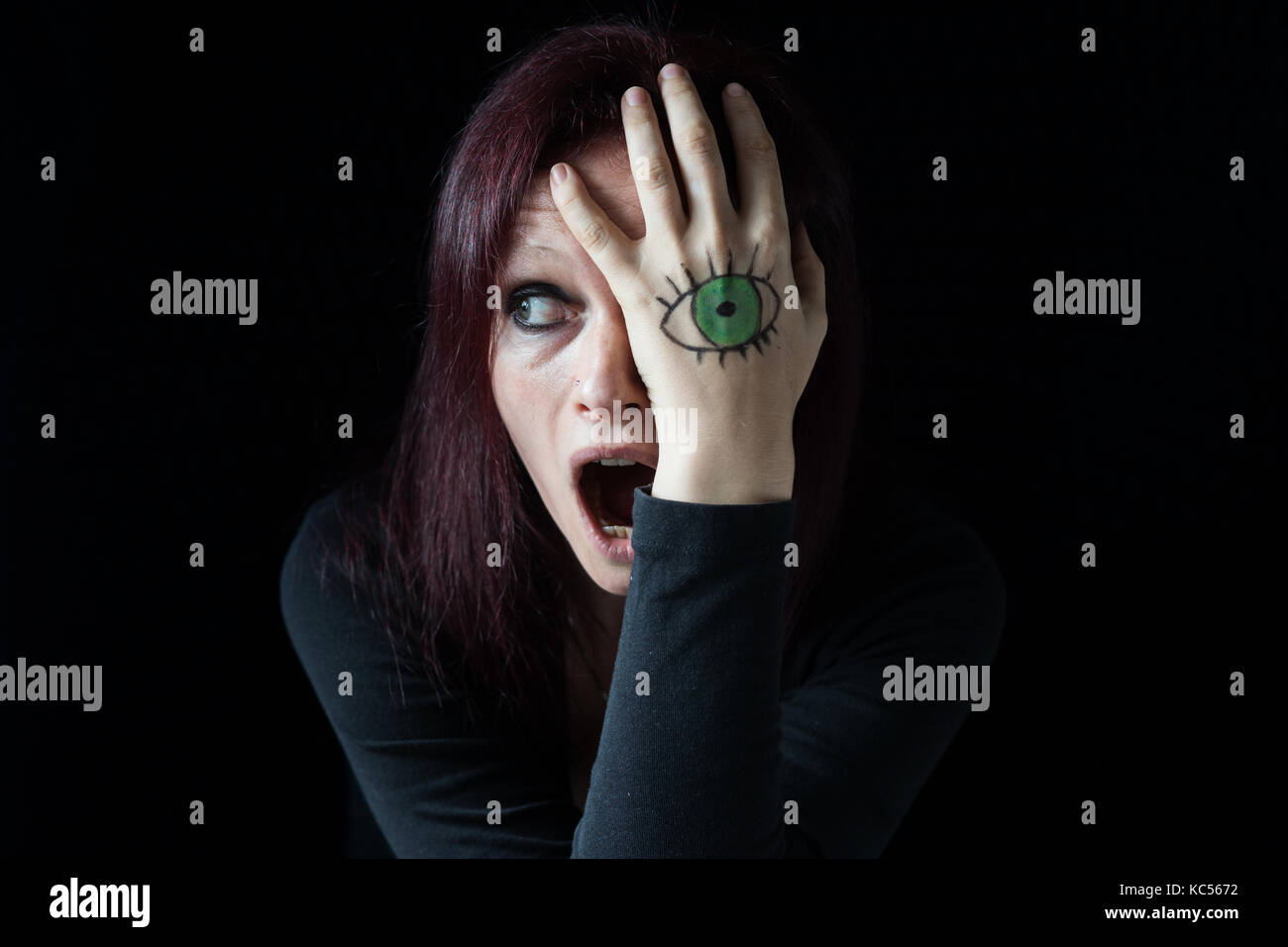 A screaming woman with a painted eye on her hands Stock Photo - Alamy