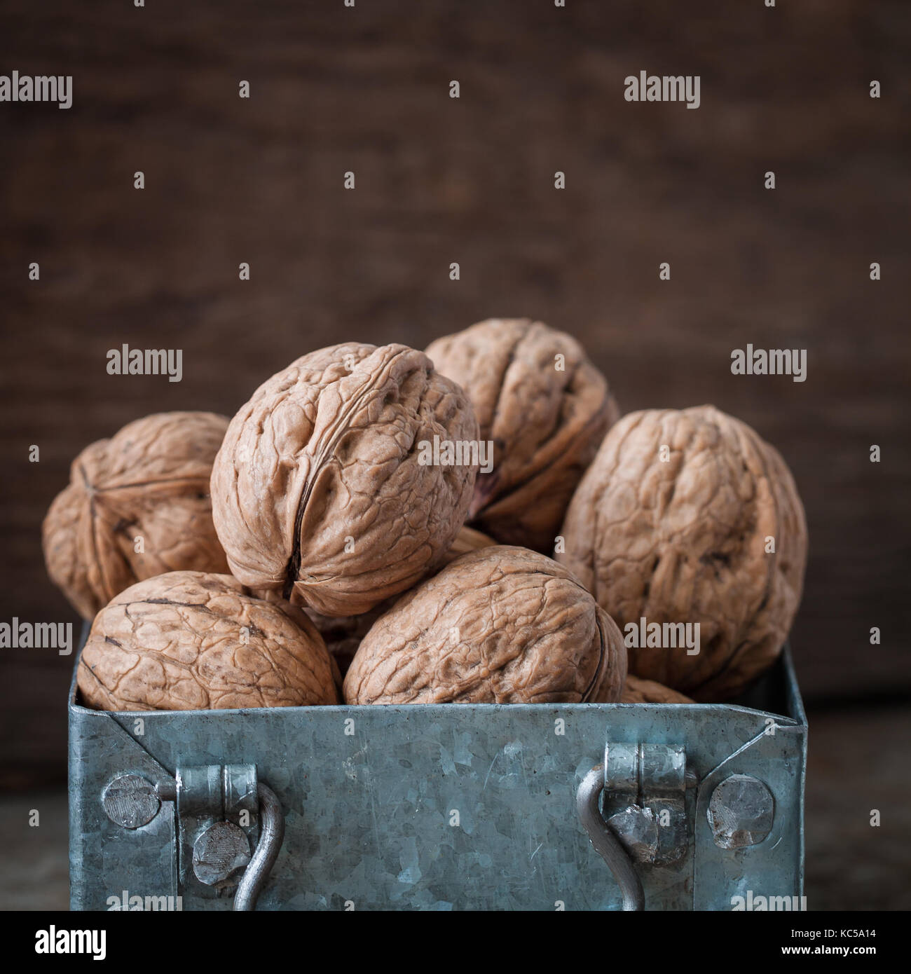 Walnuts in a small iron box. Closeup. Wooden background Stock Photo - Alamy