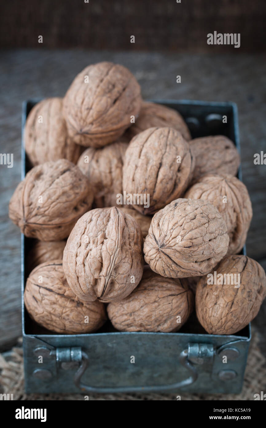 Walnuts in a small iron box and a canvas napkin. Wooden background ...