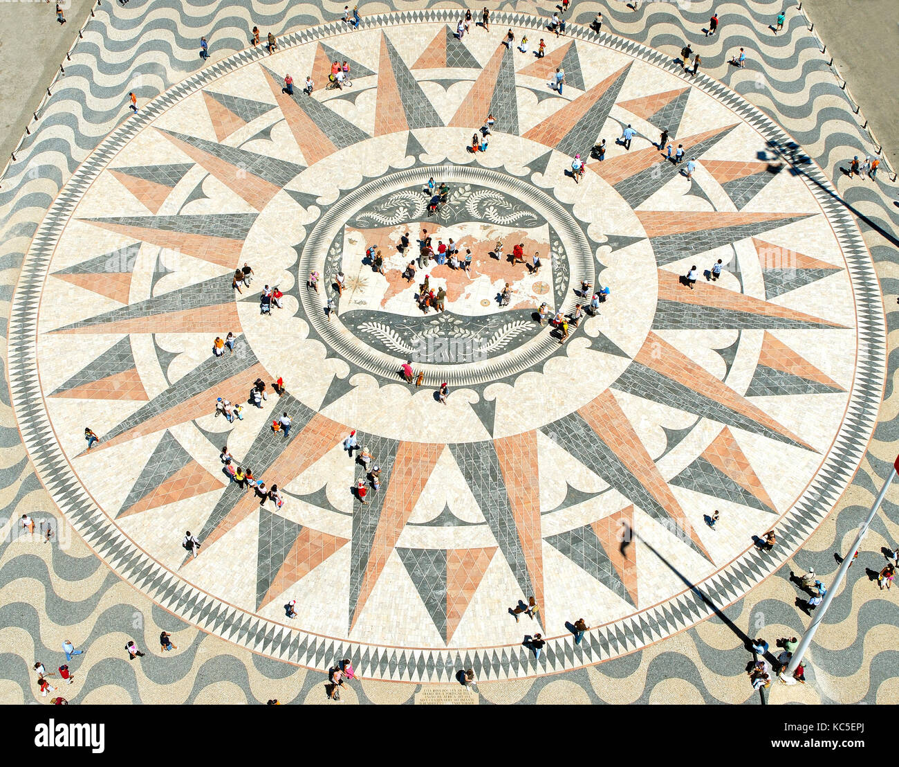 A group of tourists stand in the centre of the compass pavement in ...