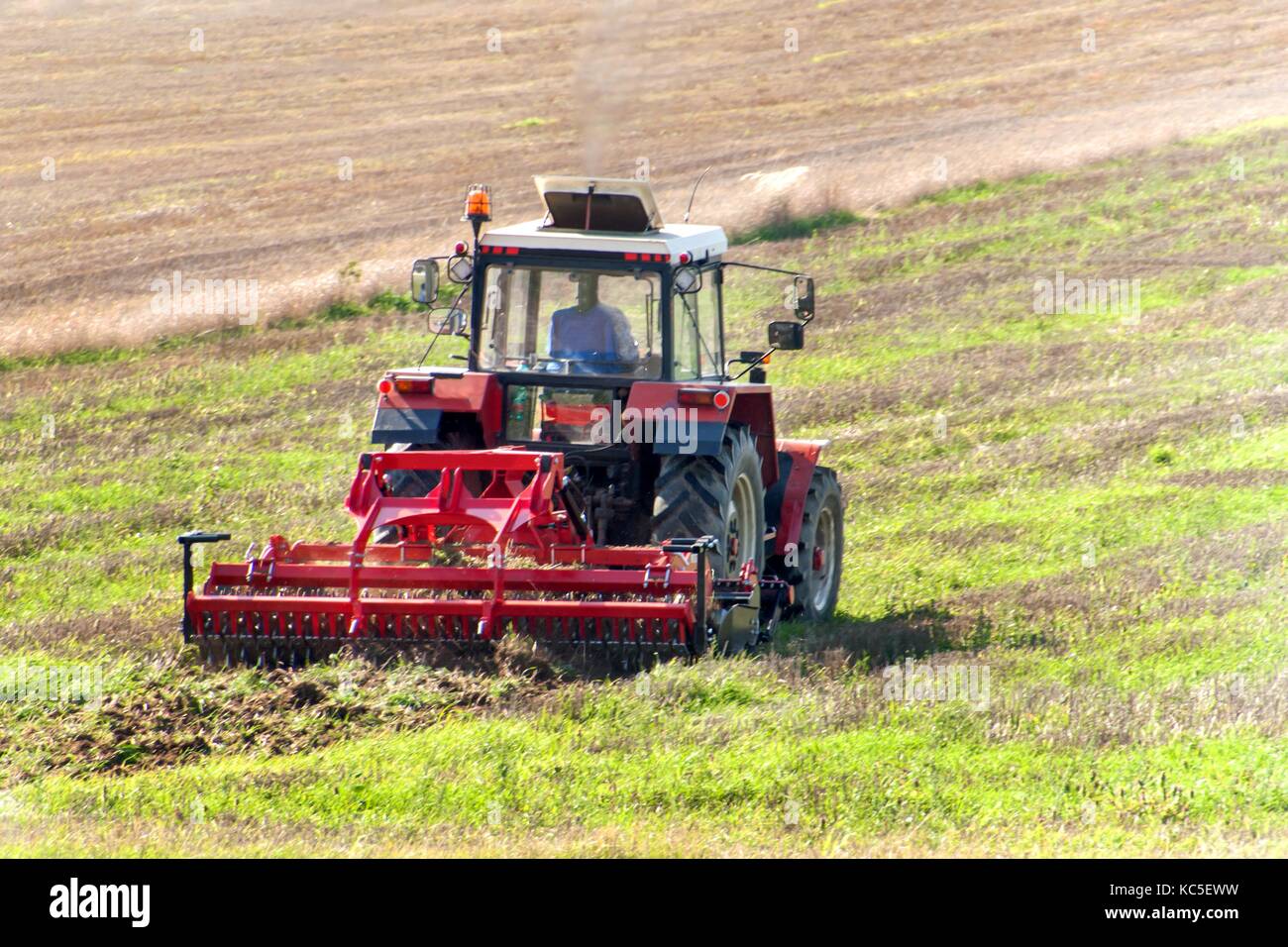 Red tractor in the field. Agricultural farm work. Agriculture in the ...