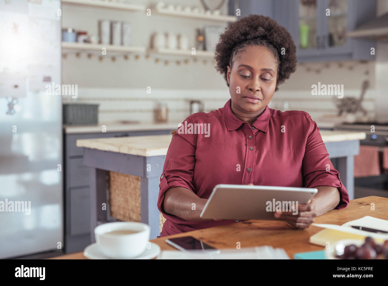 Focused African woman working on a digital tablet at home Stock Photo ...