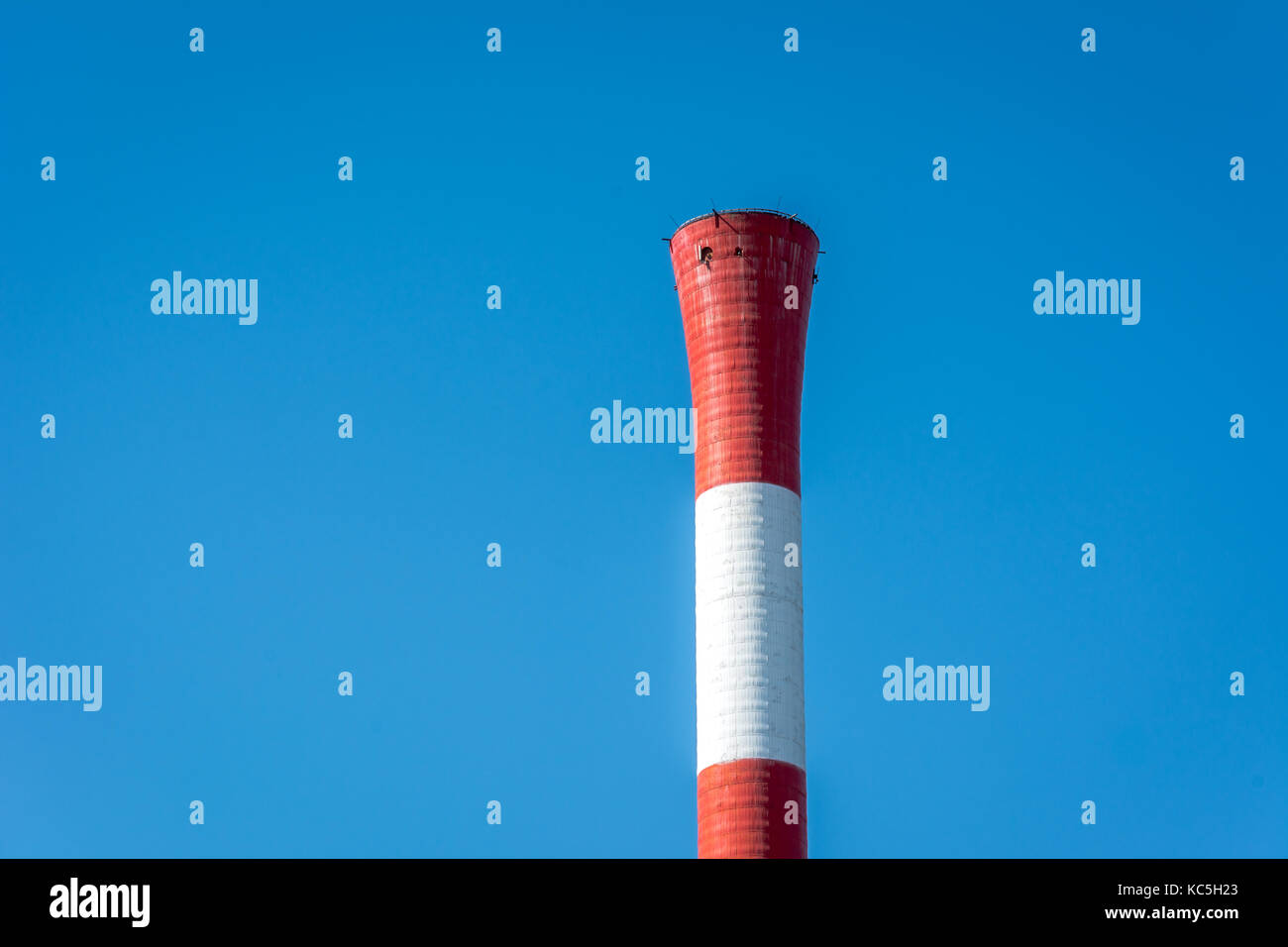 Factory chimney red white color on blue sky background right align ...