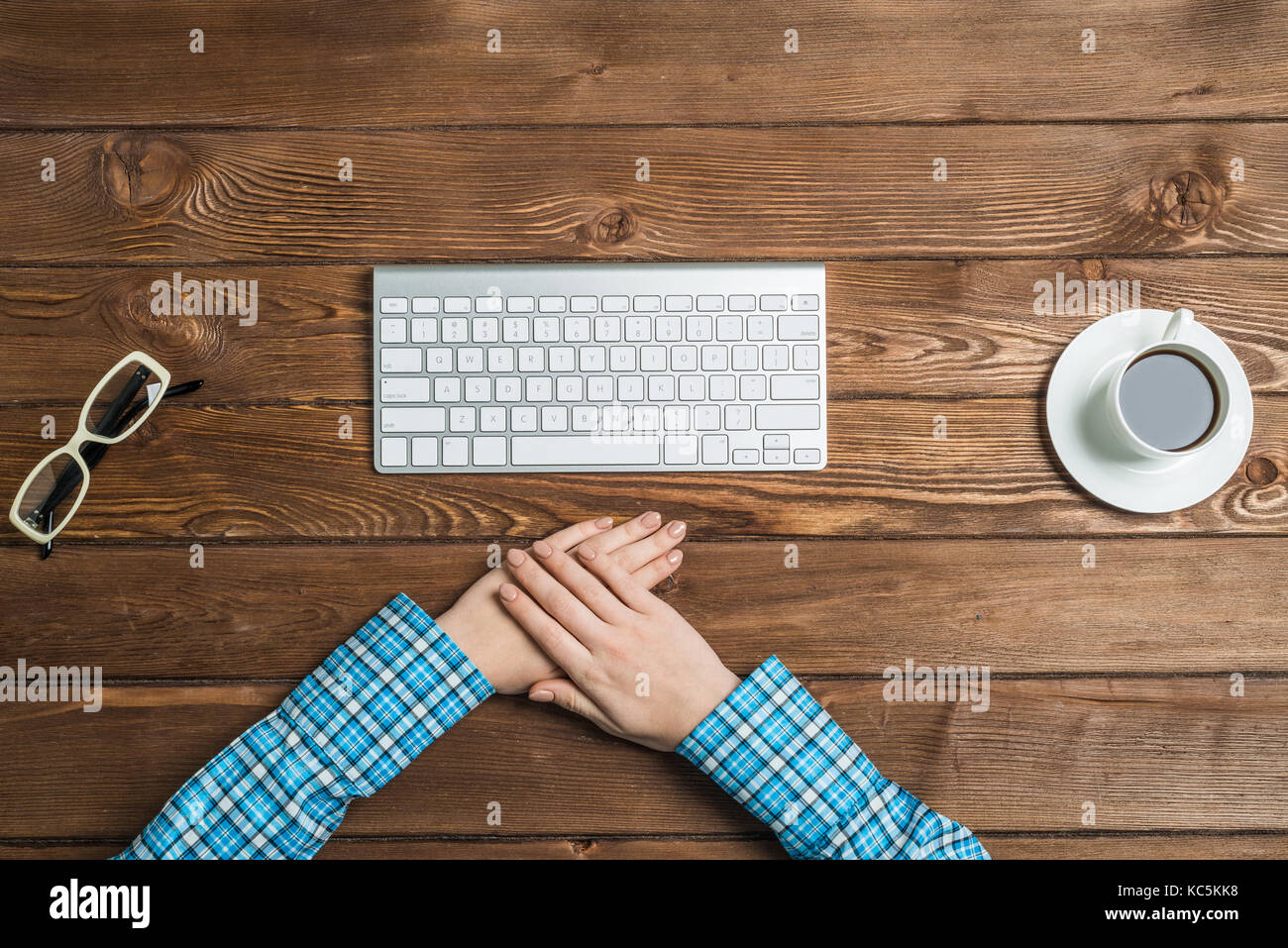 Top view of woman sitting at table with hands folded Stock Photo - Alamy