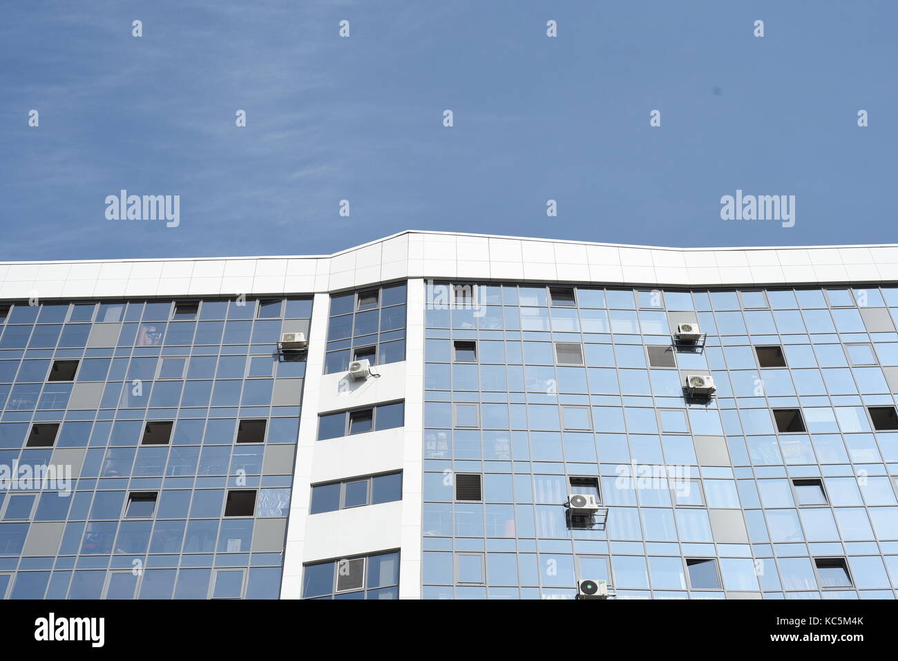 Glass panels in white and blue of a modern high rise building exterior ...