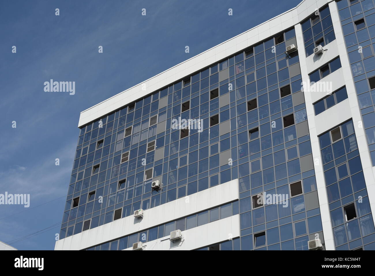 Glass panels in white and blue of a modern high rise building exterior ...