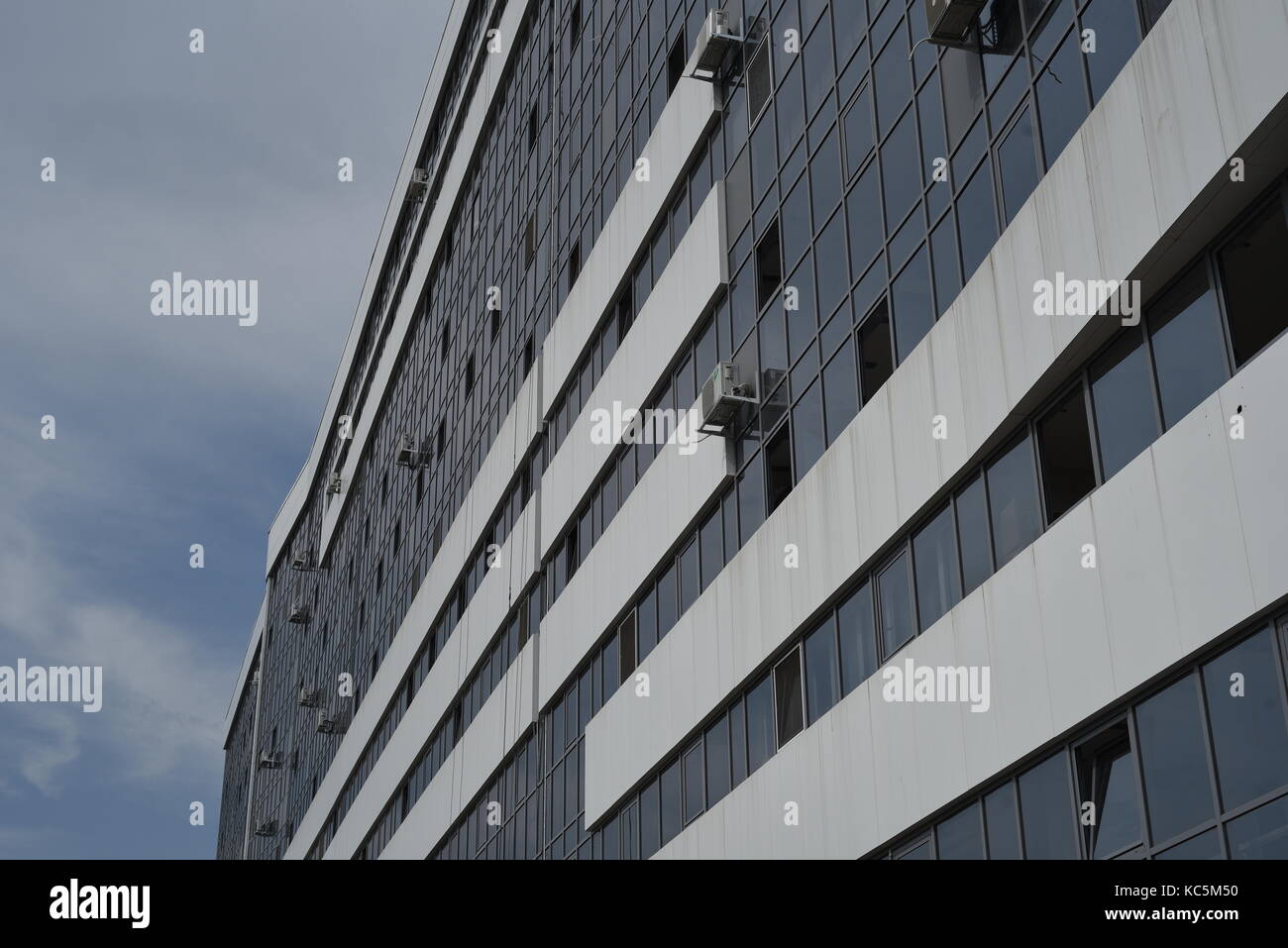 Glass panels in white and blue of a modern high rise building exterior ...