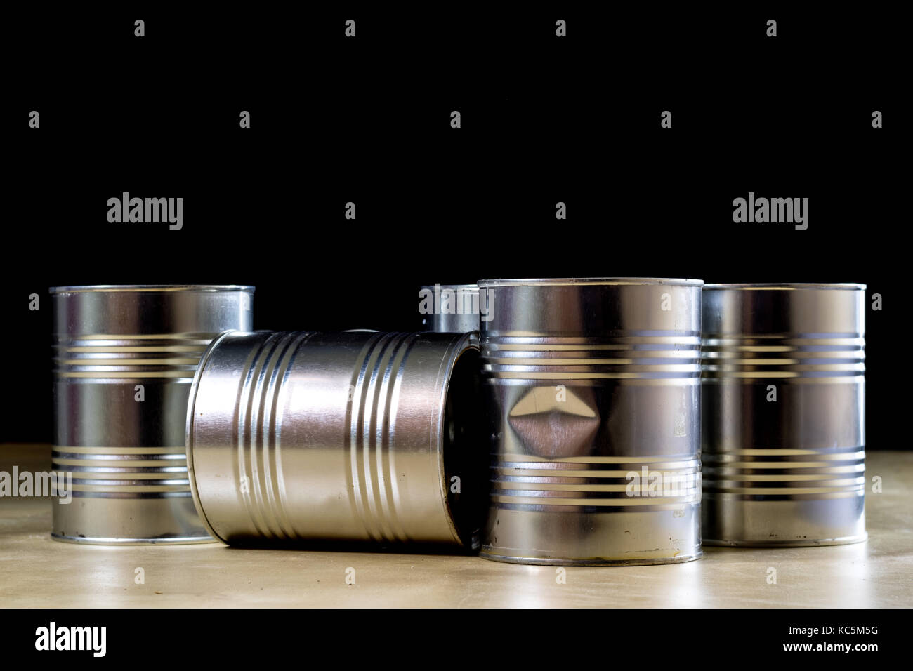 Paint tins set on a workshop table. Table with light wood, black ...