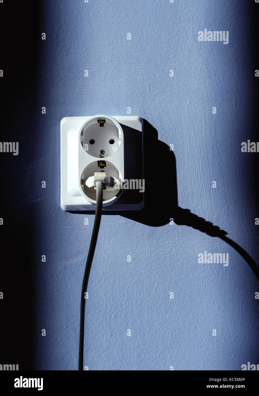 Electrical plug socket with electric cable inserted into one of the ...