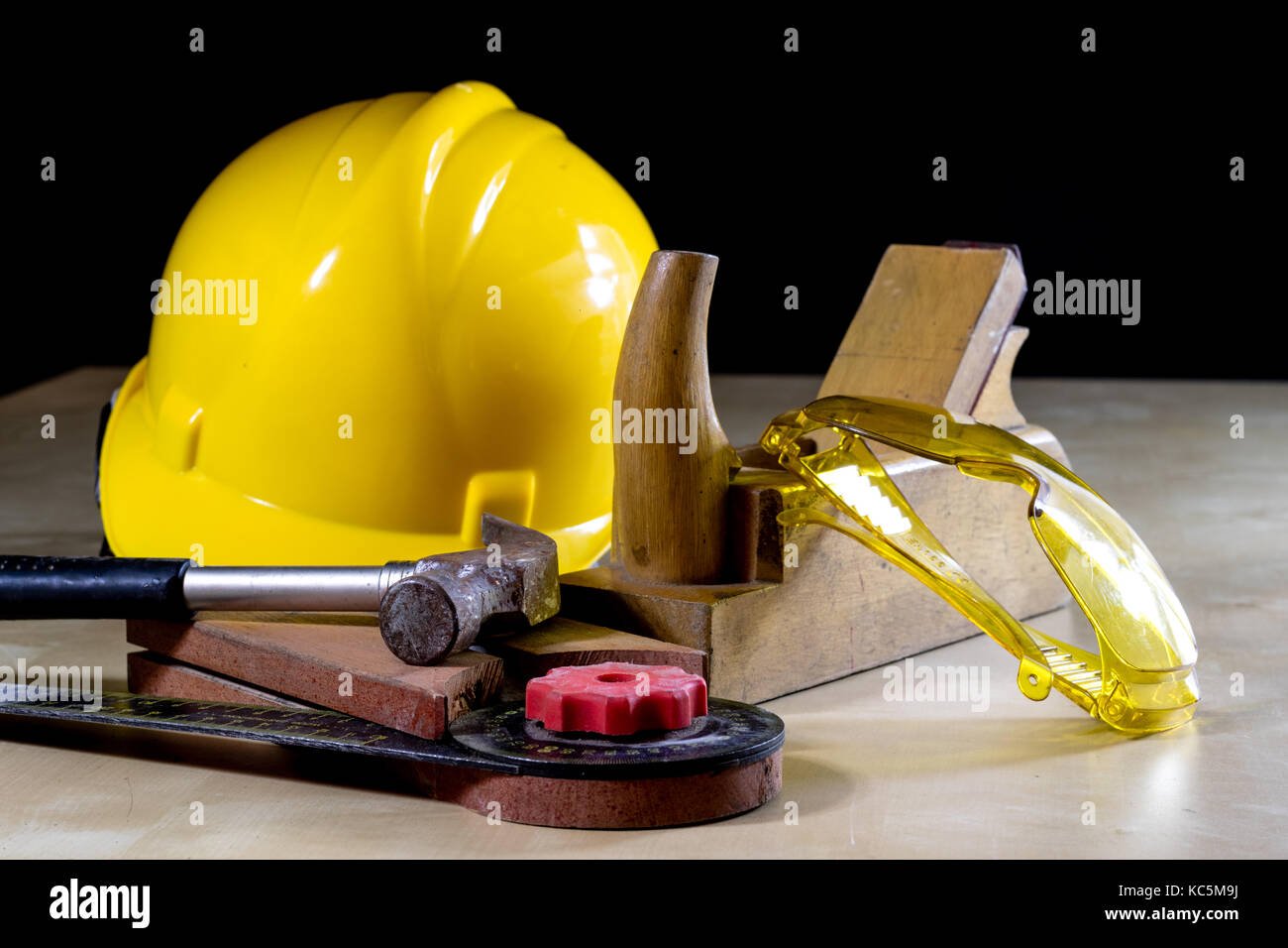 helmet and carpenter tools on the workbench. Glasses, hammer and ...