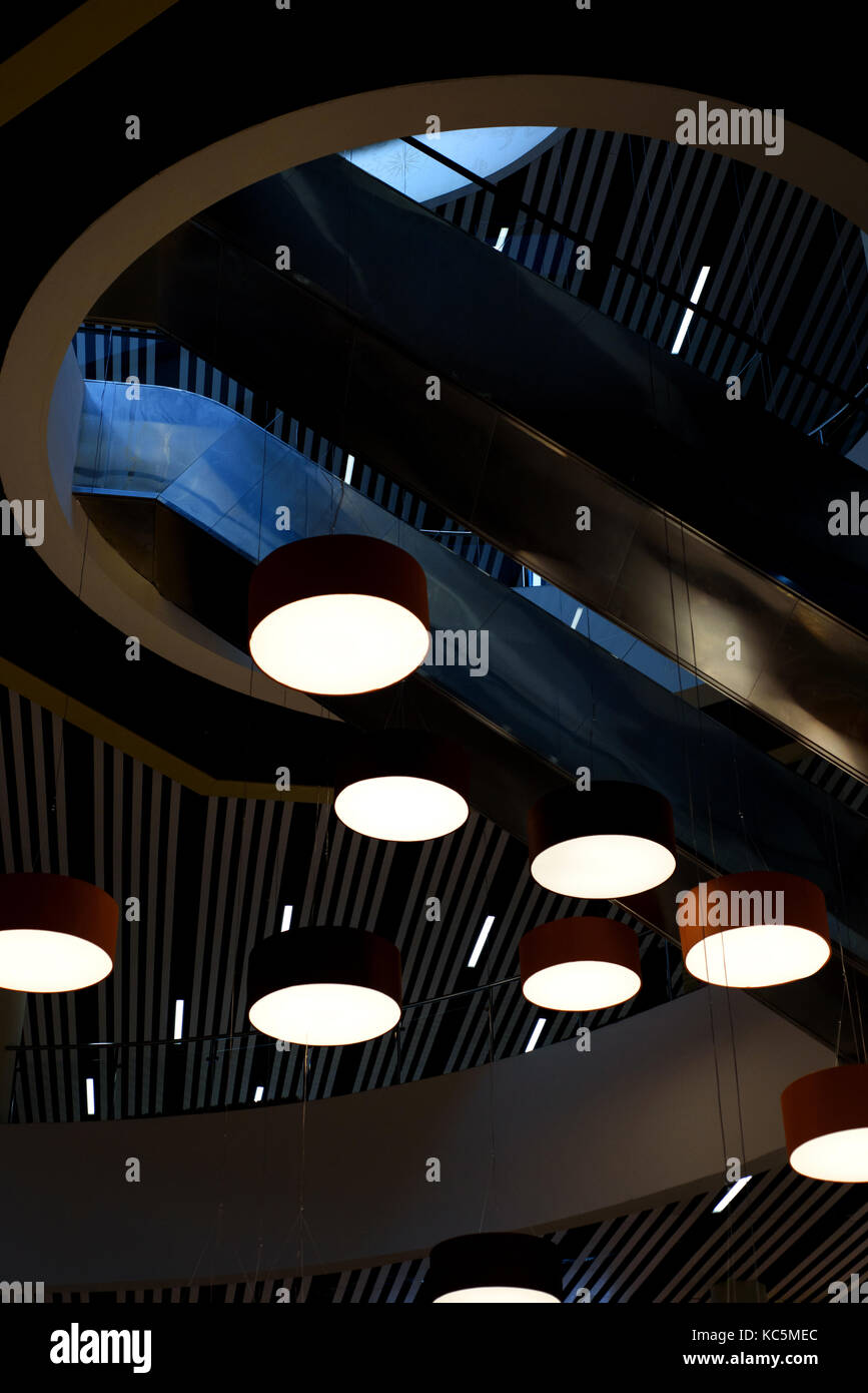 Circular Modern lights hang from the ceiling of a modern building ...