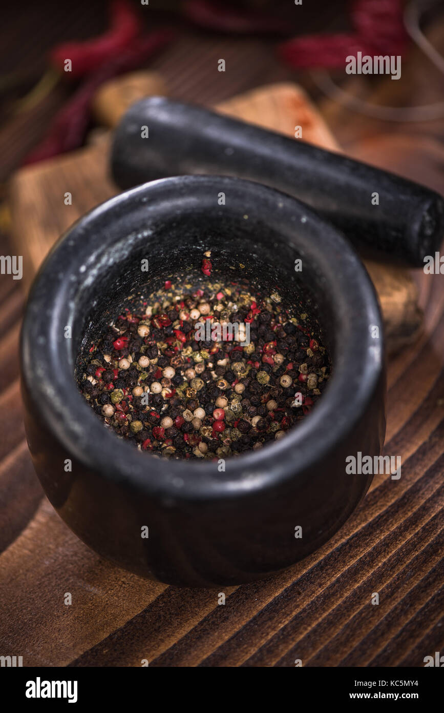 Mixed pepper seeds in stone mortar Stock Photo - Alamy