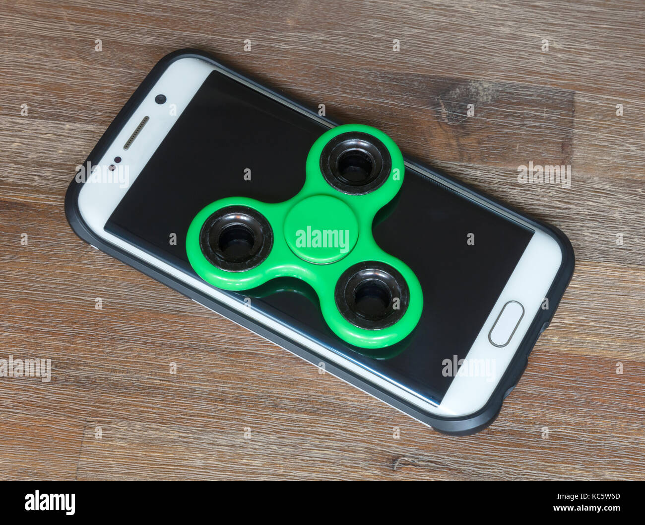 Childrens toys; Smartphone with a green spinner on top Stock Photo - Alamy