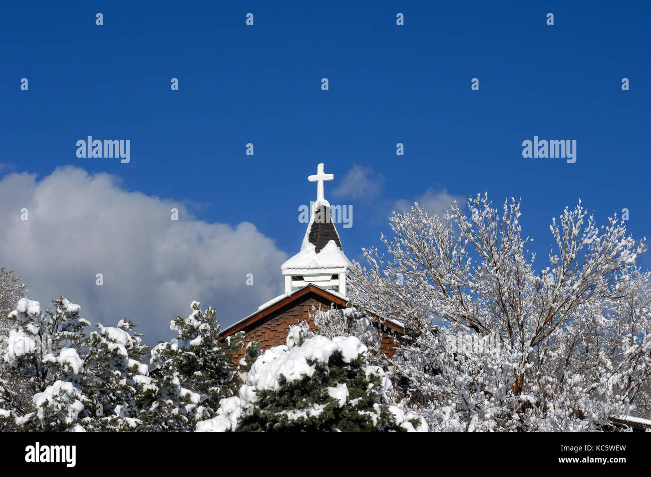 Catholic Mission is covered by a fresh covering of snow. Church steeple ...