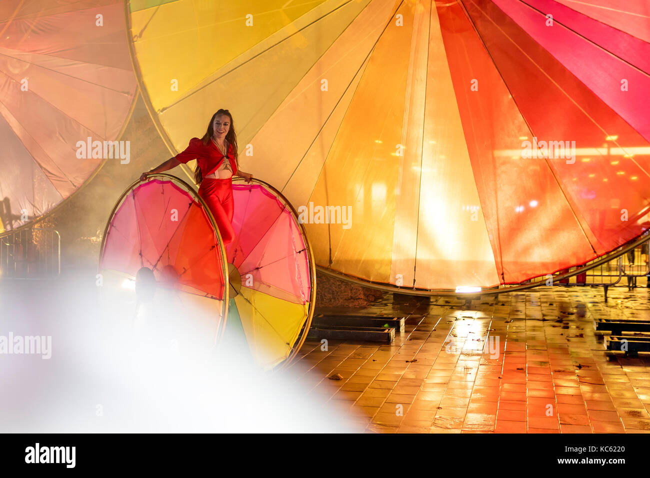 Street performer on colour wheel at a street festival at night in the ...