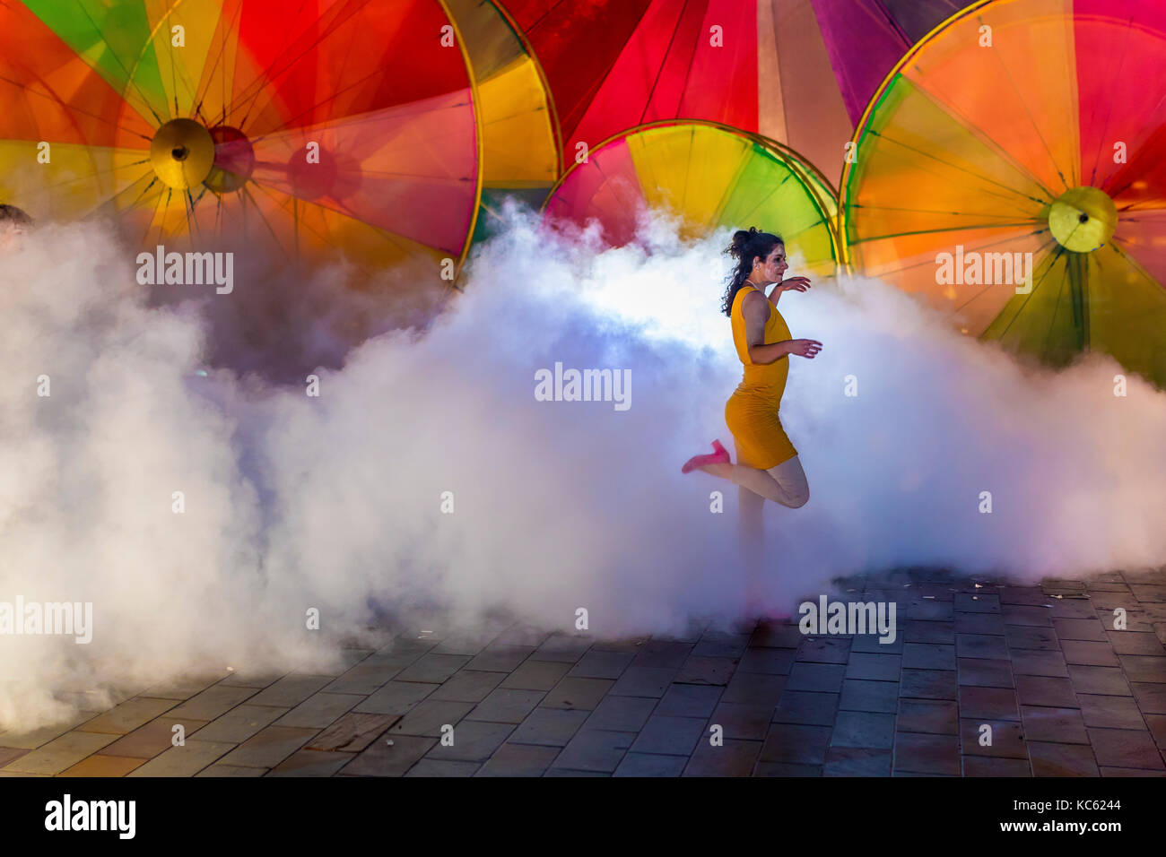 Street festival performer dancing through dry ice in front of a ...