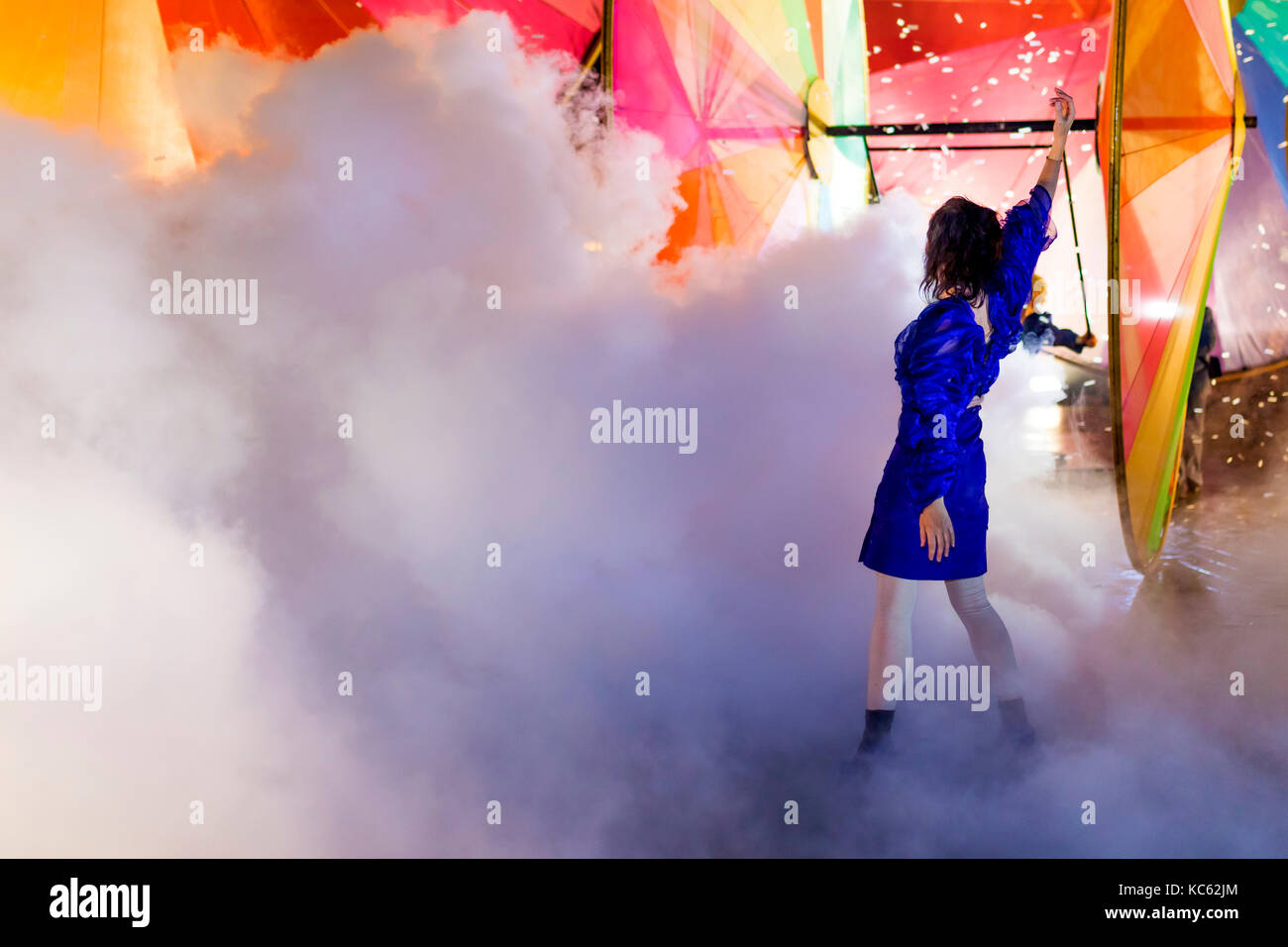 Street festival performer dancing in front as dry ice surrounds her ...