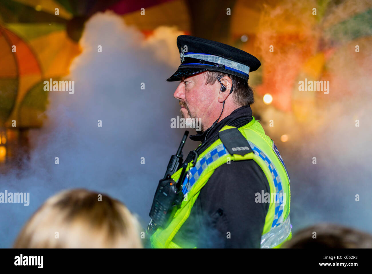 Police officer against a colourful smoke festival background provides ...