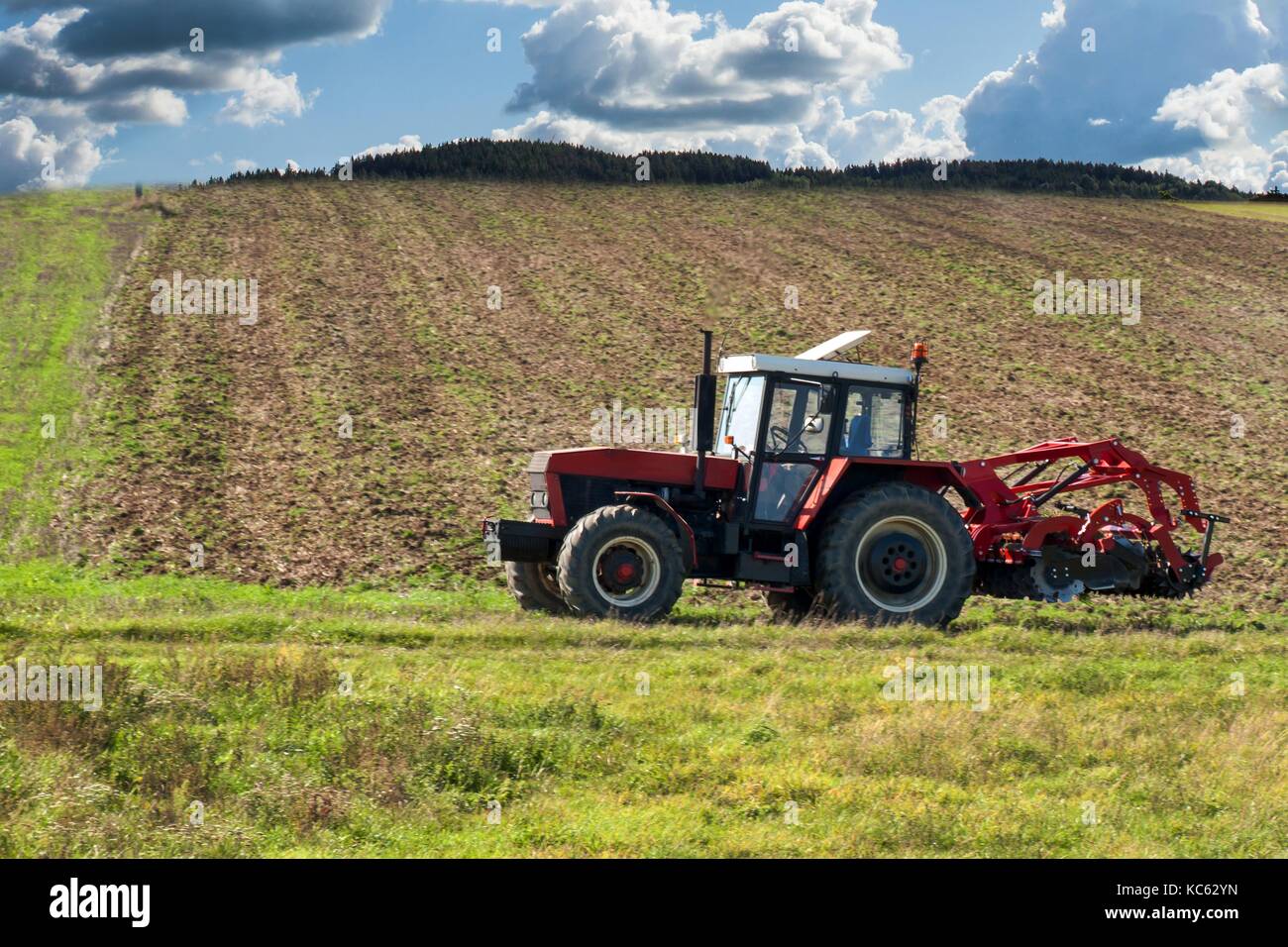 Red tractor in the field. Agricultural farm work. Agriculture in the ...