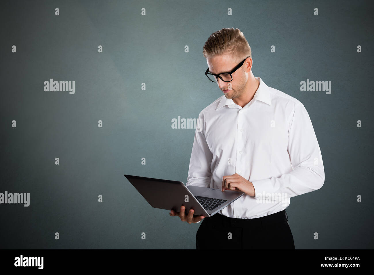 Businessman Using Laptop Computer Against Grey Background Stock Photo ...