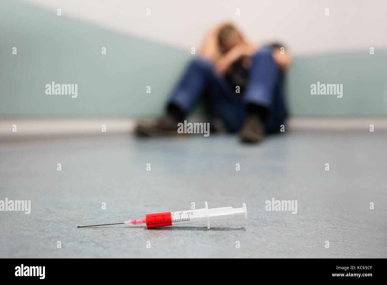 Drug Addicted Person With Syringe On The Floor Stock Photo - Alamy