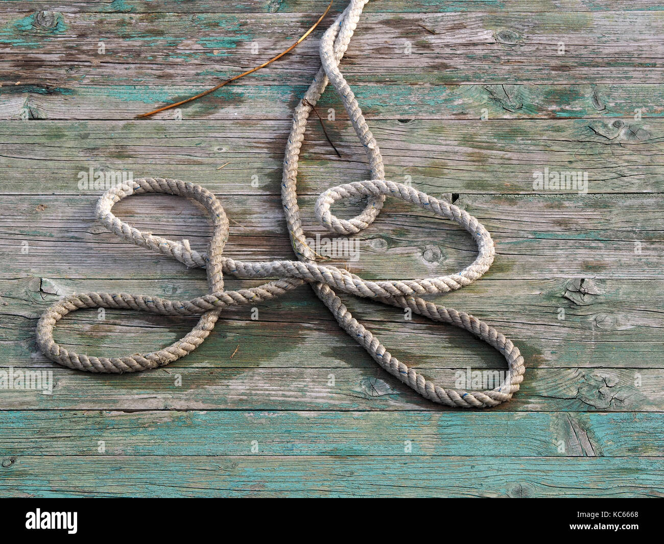 wet mooring rope coiled on faded wooden surface in Tuscany, Italy Stock ...