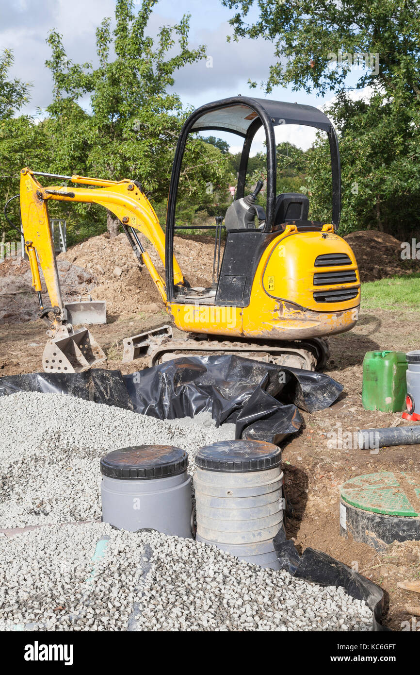 A mini digger or excavator being used to install the sand and gravel ...
