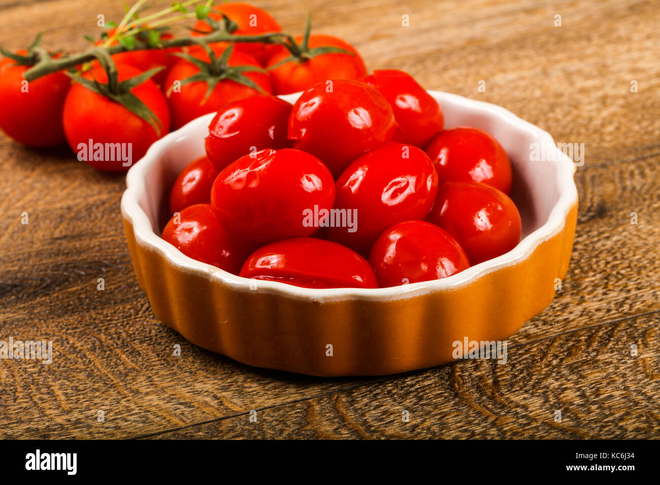 Pickled cherry tomatoes heap on the wooden background Stock Photo - Alamy