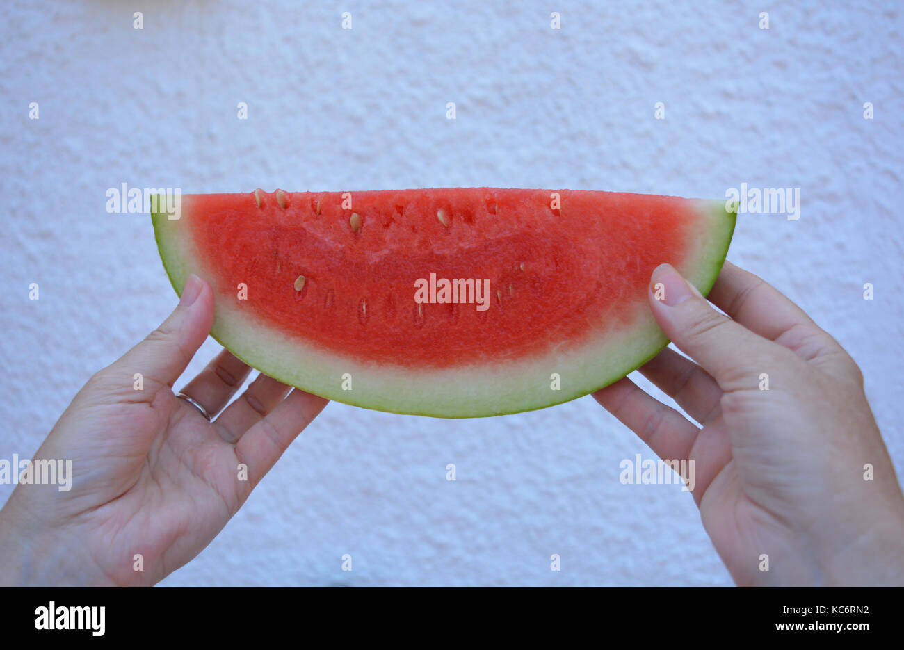 A piece of watermelon in a woman's hands Stock Photo - Alamy