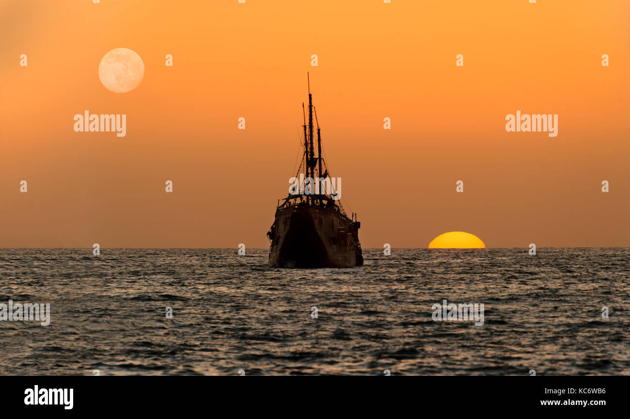 Ocean sunset ship silhouette is an old wooden ship sitting at sea ...