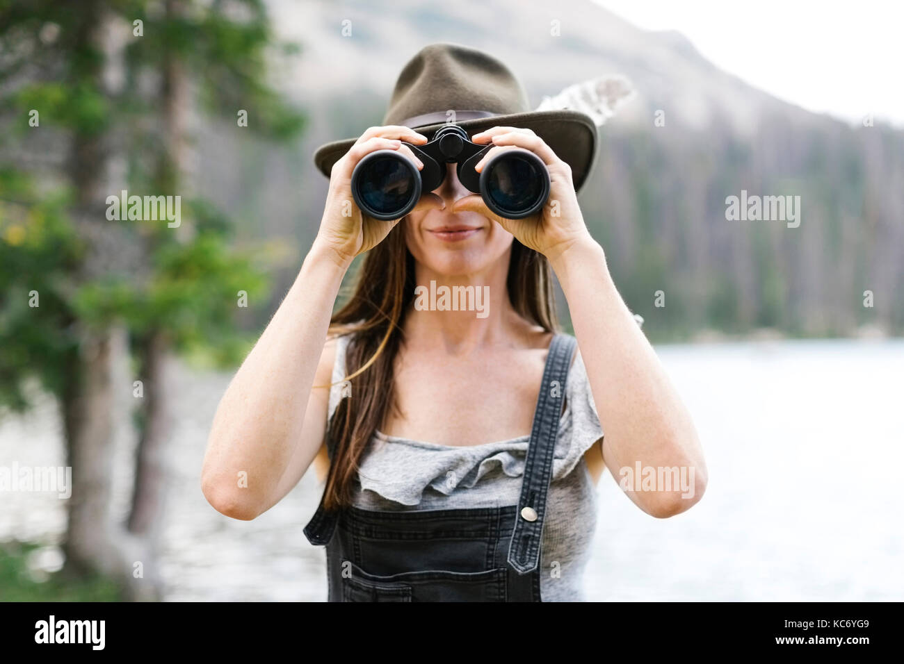Woman using binoculars Stock Photo - Alamy