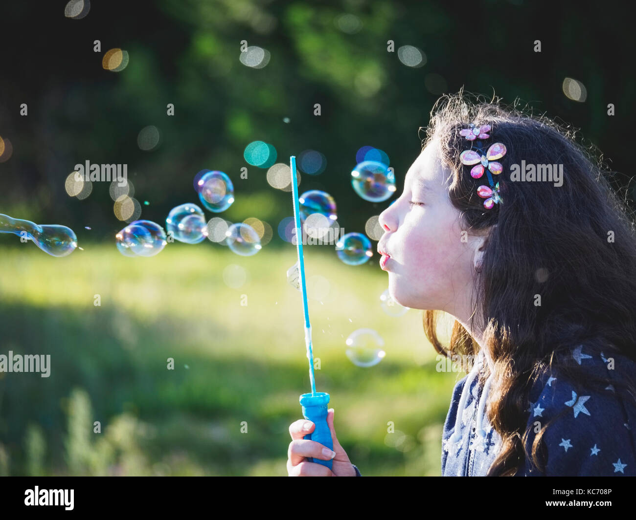 Girl (10-11) blowing bubbles Stock Photo - Alamy