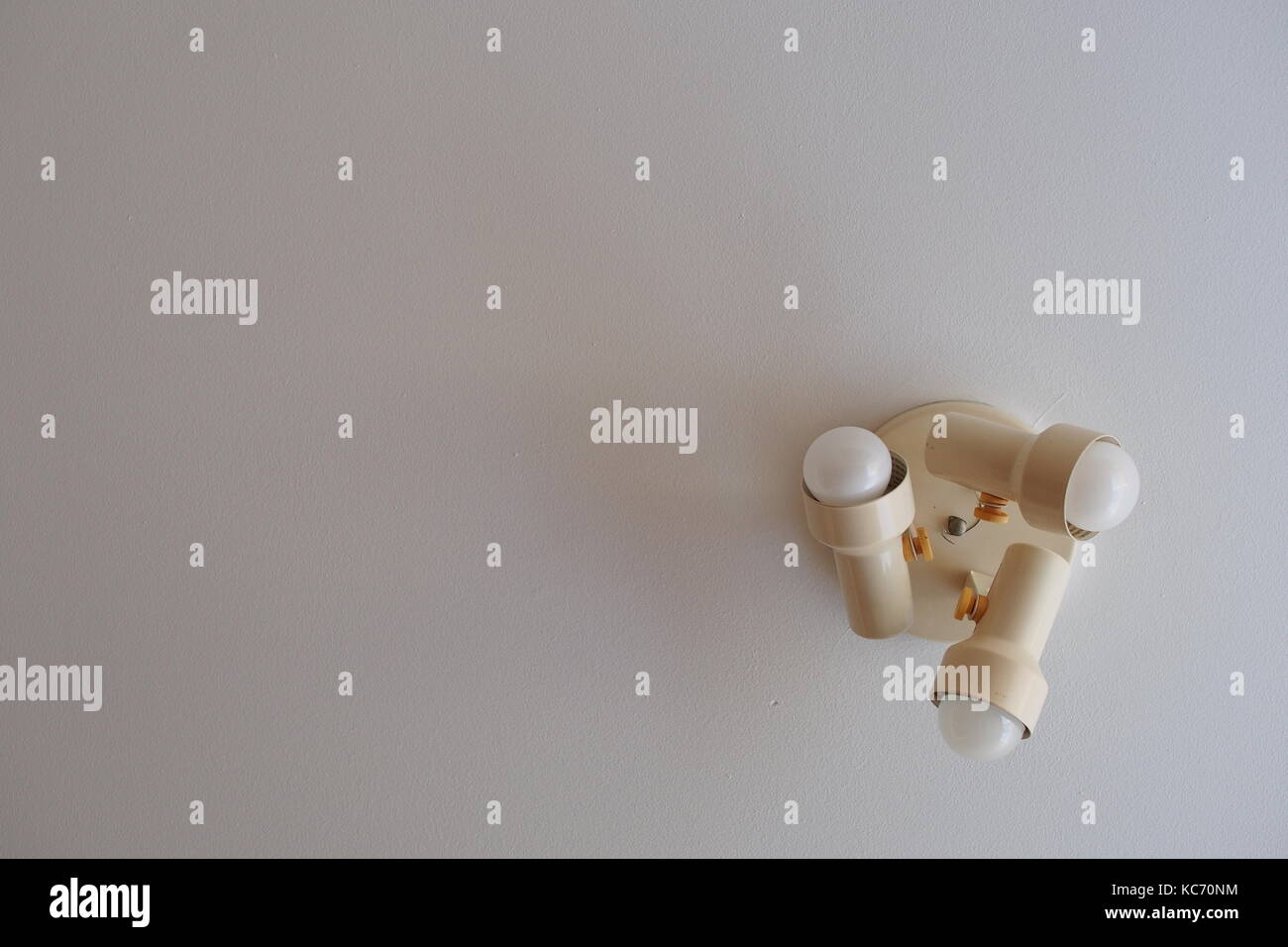 Bare triple ceiling spotlights on a plain white ceiling Stock Photo - Alamy