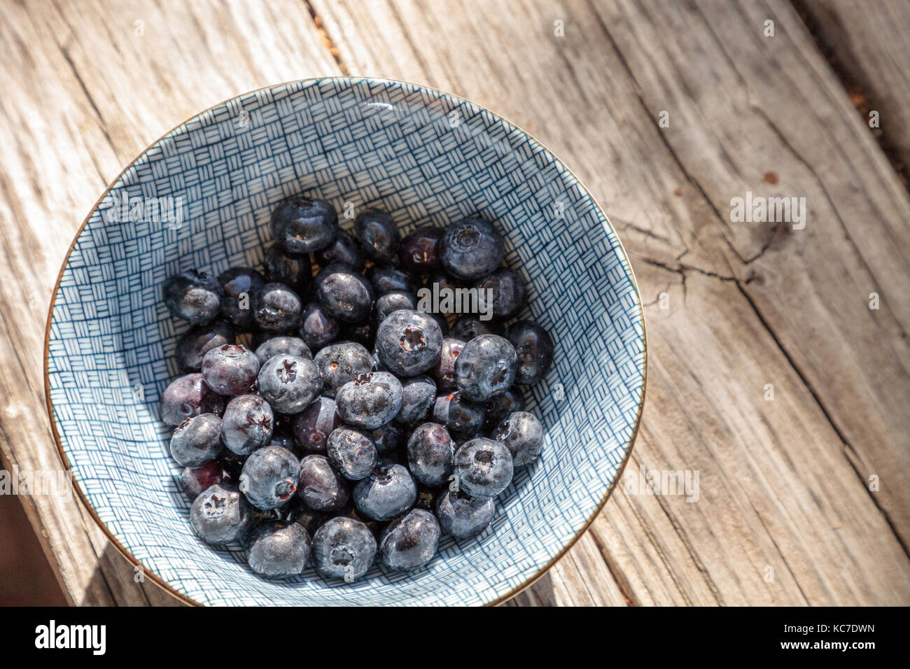 Organic blueberries in a blue and white bowl on the rustic wood ...