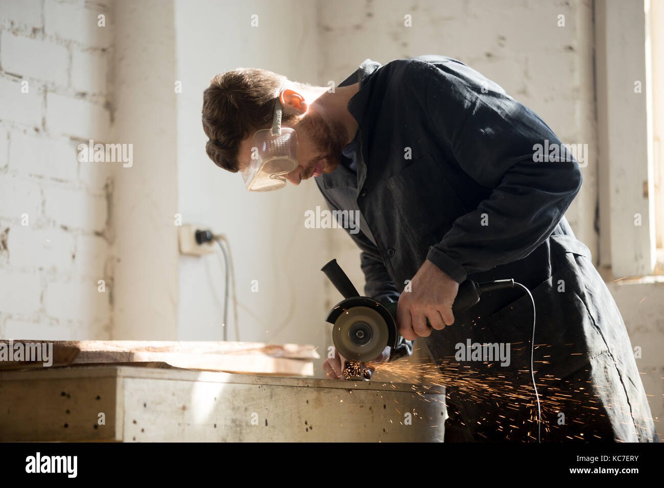Side view of worker using angle grinder for metal cutting Stock Photo ...