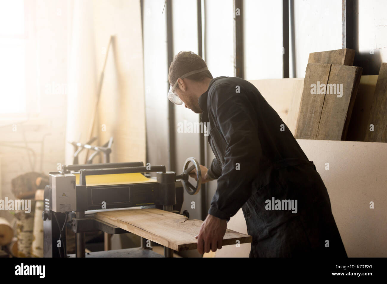 Worker operating stationary power planer, processing wooden boar Stock ...