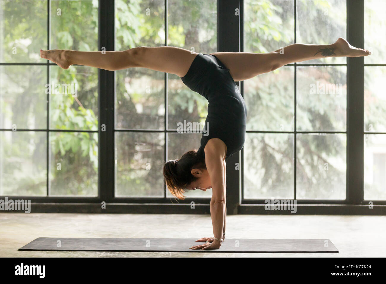 Young attractive woman in Handstand pose, home background Stock Photo ...
