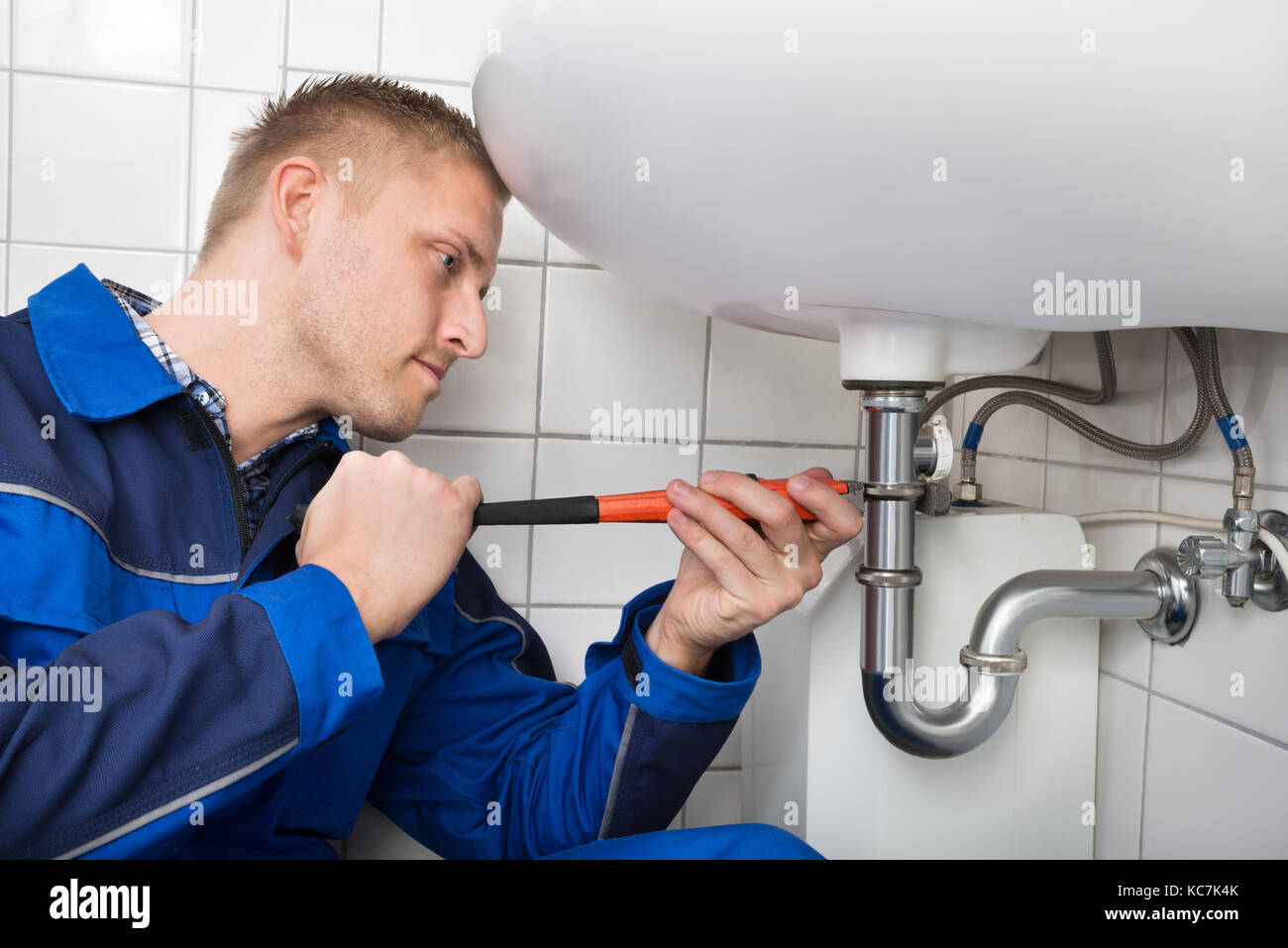 Young Male Plumber Fixing Sink In Bathroom Stock Photo - Alamy
